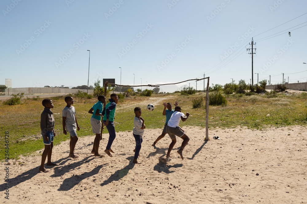 Kids playing football in the ground Stock Photo | Adobe Stock