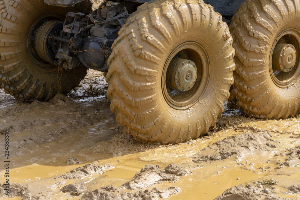 big wheels in the mud. The large wheels of a truck stuck in the mud ...