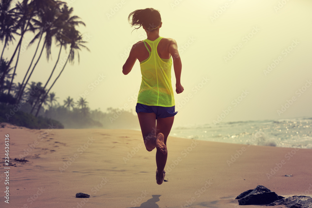 Fitness healthy lifestyle young woman running on tropical beach during ...