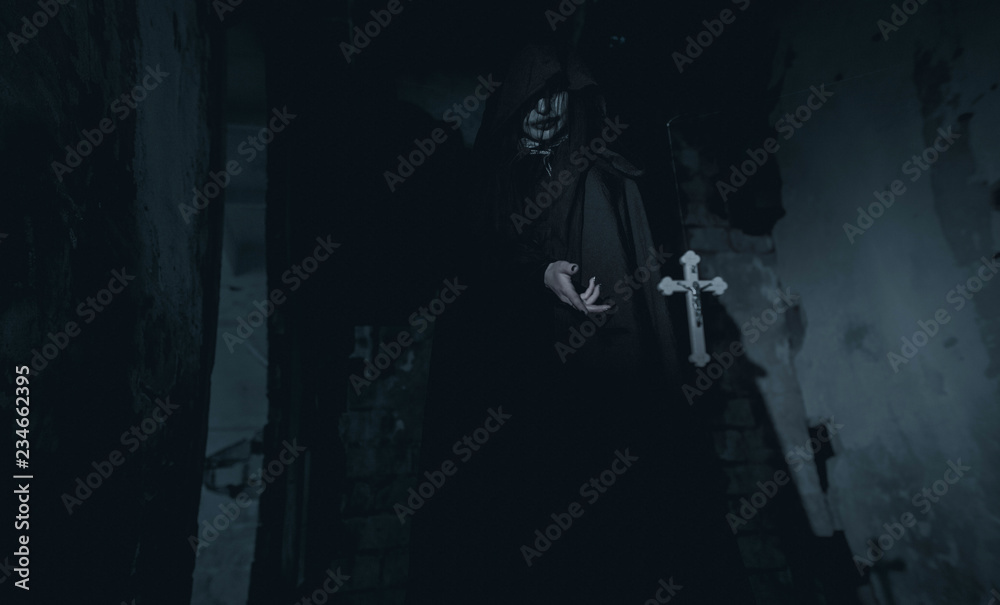 Woman is standing in a darkness next to the cross flying in the air in ...