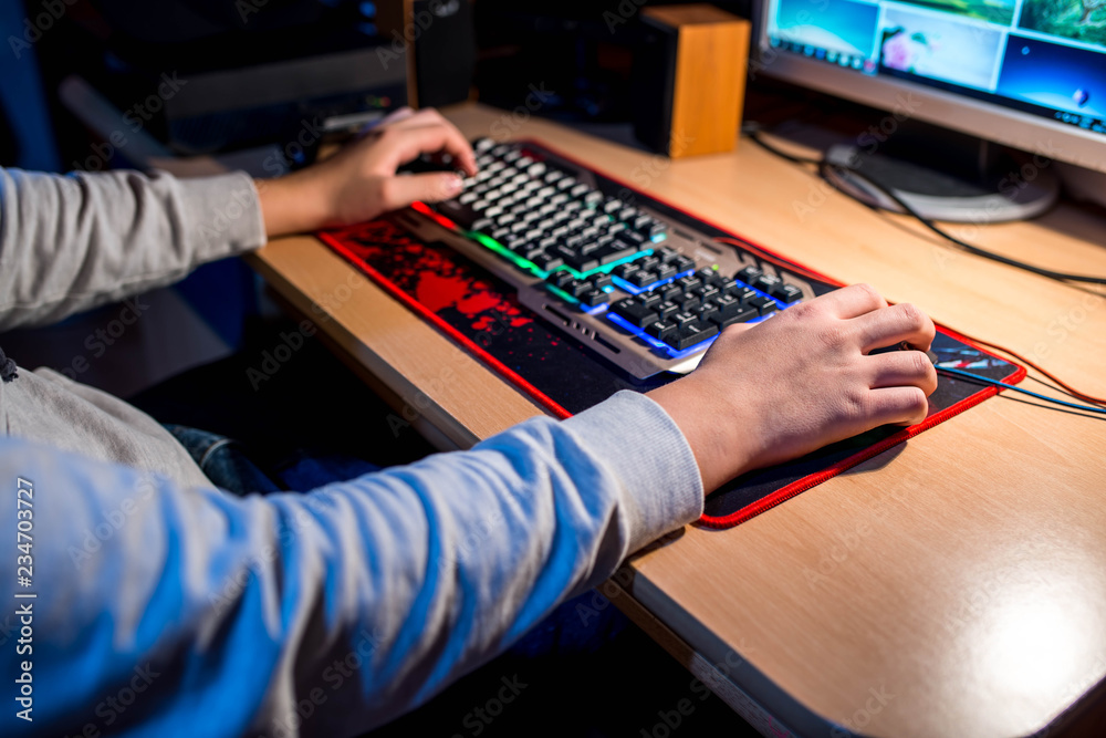 Teenage boy playing computer games, gamer mouse and keypad, focus on ...
