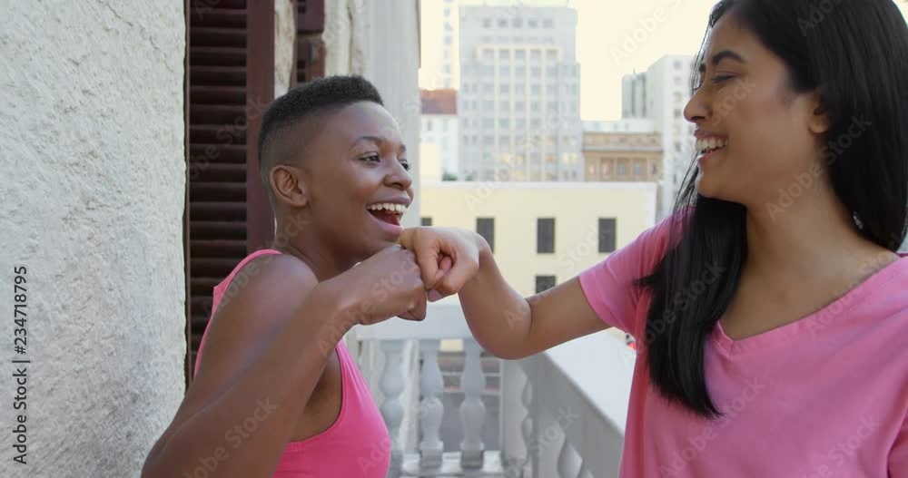 Women giving fist bump in balcony at home 4k Stock Video | Adobe Stock
