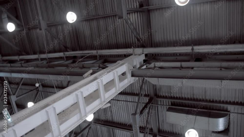 Hangar ceiling with many structural beams, ventilation pipes and ...