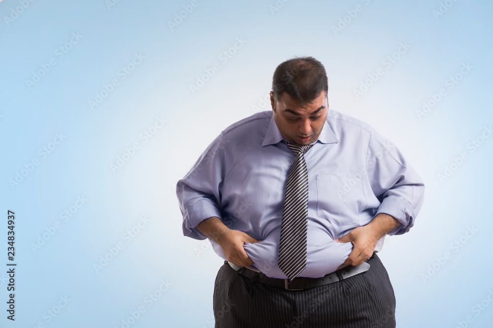 Obese man in formal clothes holding his belly fat with both hands ...