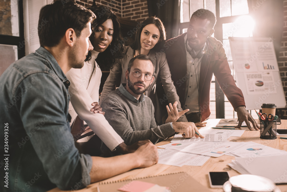 concentrated multiethnic group of colleagues working together on new ...