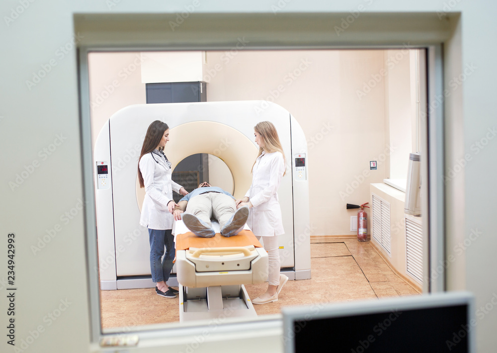 MRI machine and screens with doctor and nurse Stock Photo | Adobe Stock
