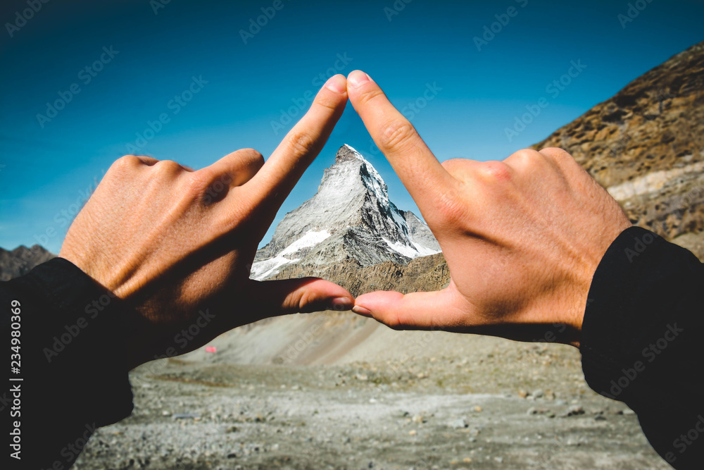 human hand forming a triangle in front of matterhorn mountain Stock ...