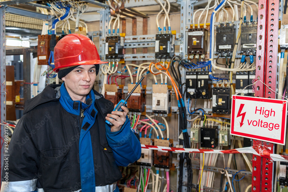 electromechanic in electrical safety gloves holds power cable, cabling ...