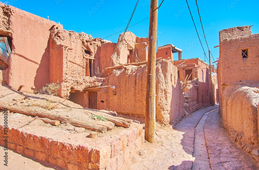 The narrow street, lined with old abandoned buildings and restored ...