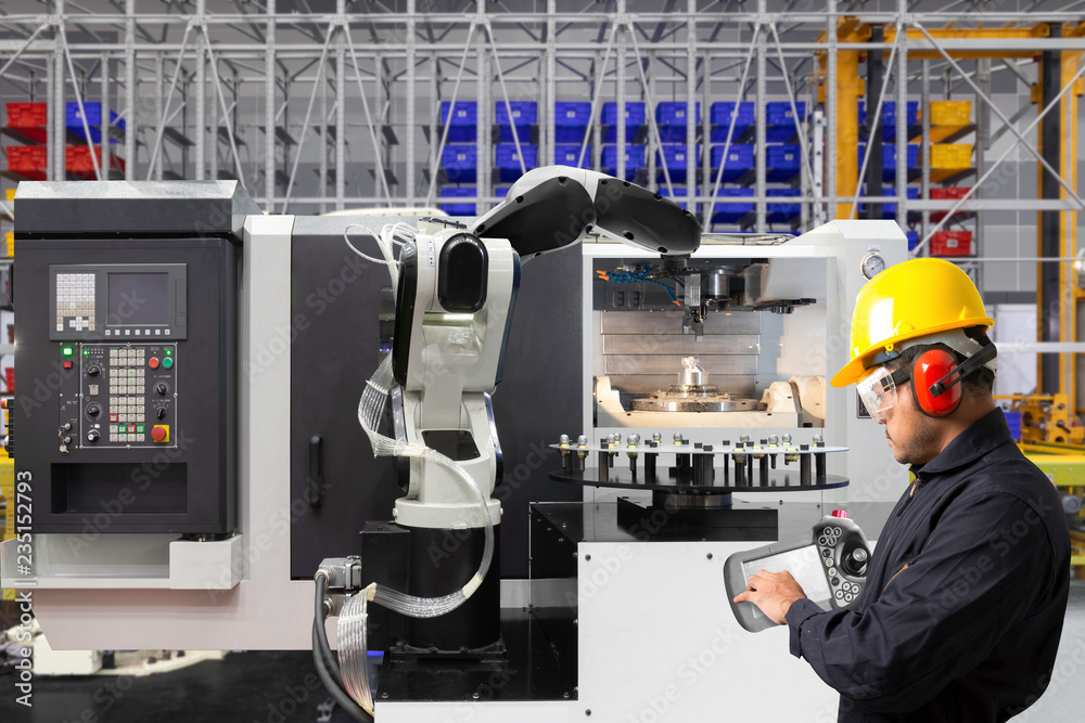 Mechanical technician operating programming on control panel of robotic ...