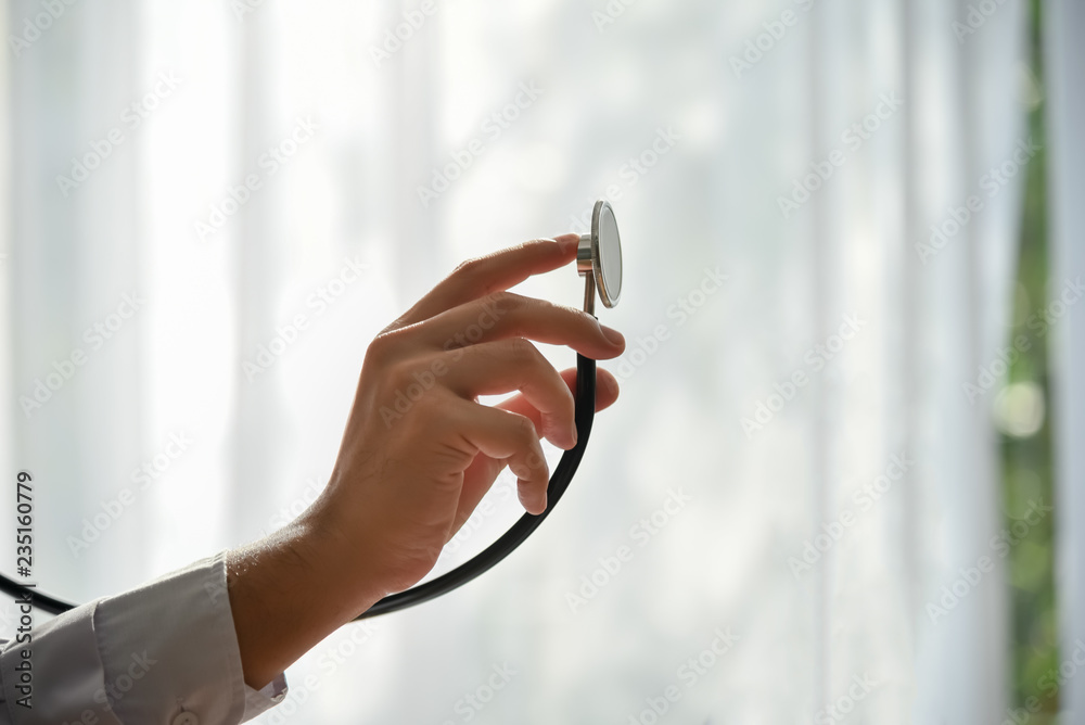 Asian male doctor holding Stethoscope which is a device To check the ...