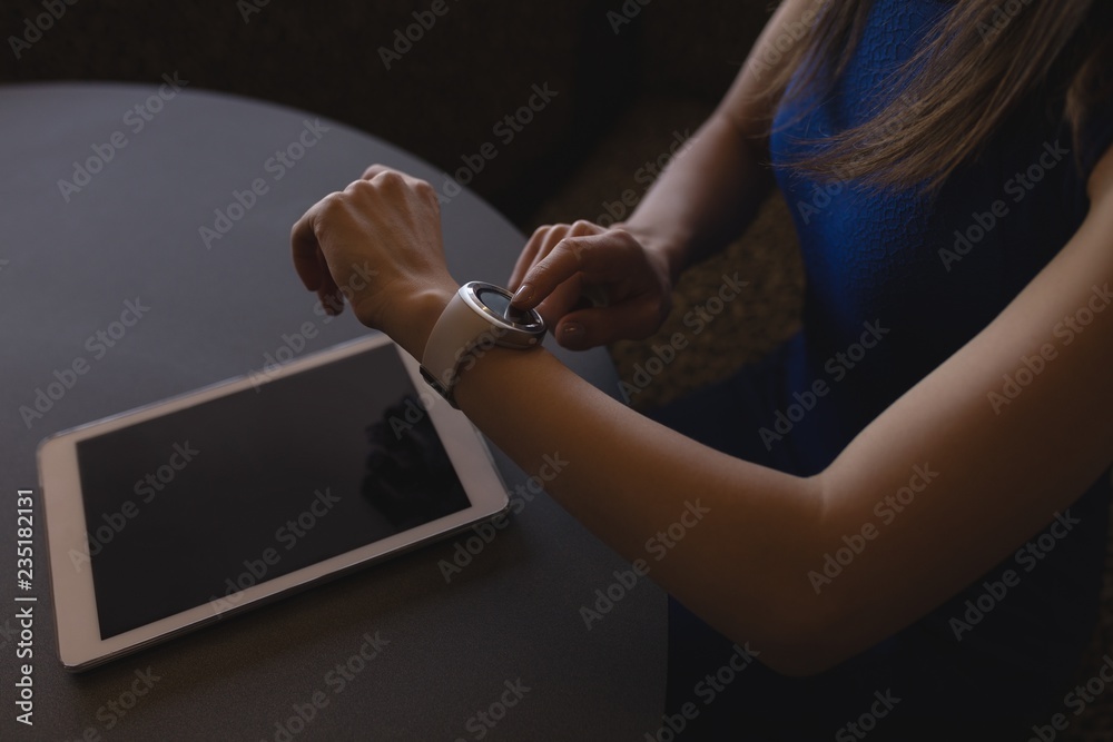 Female executive using smartwatch in office Stock Photo | Adobe Stock