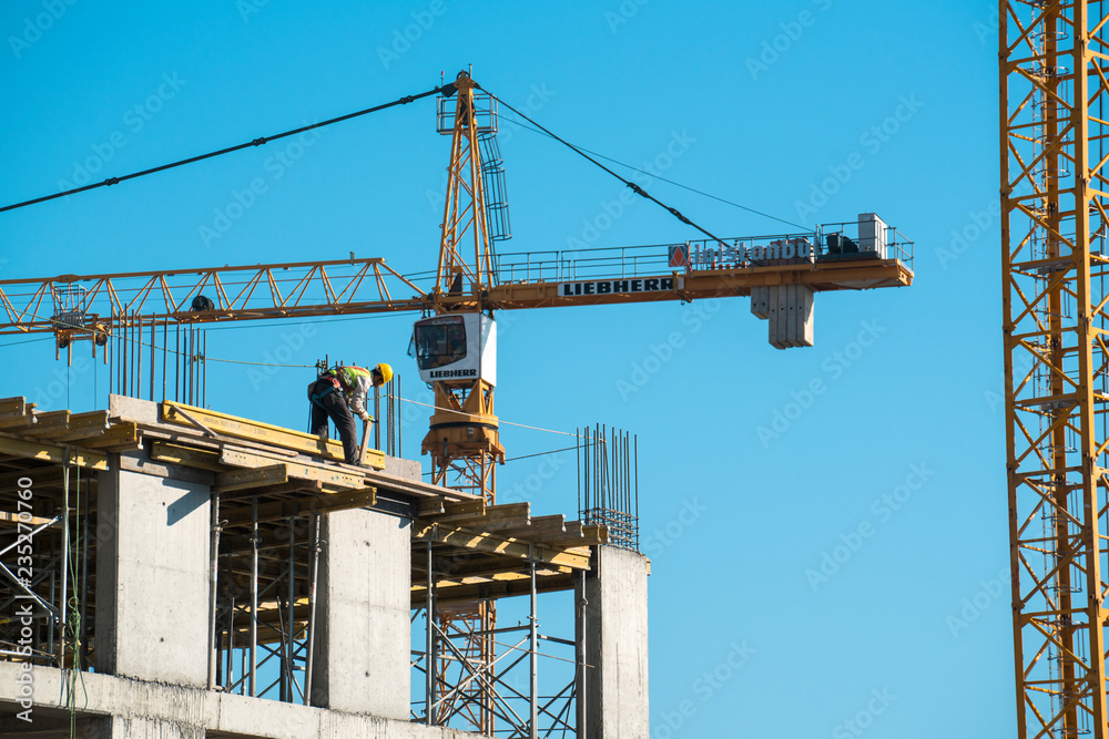 Construction worker works top of the building with crane background ...