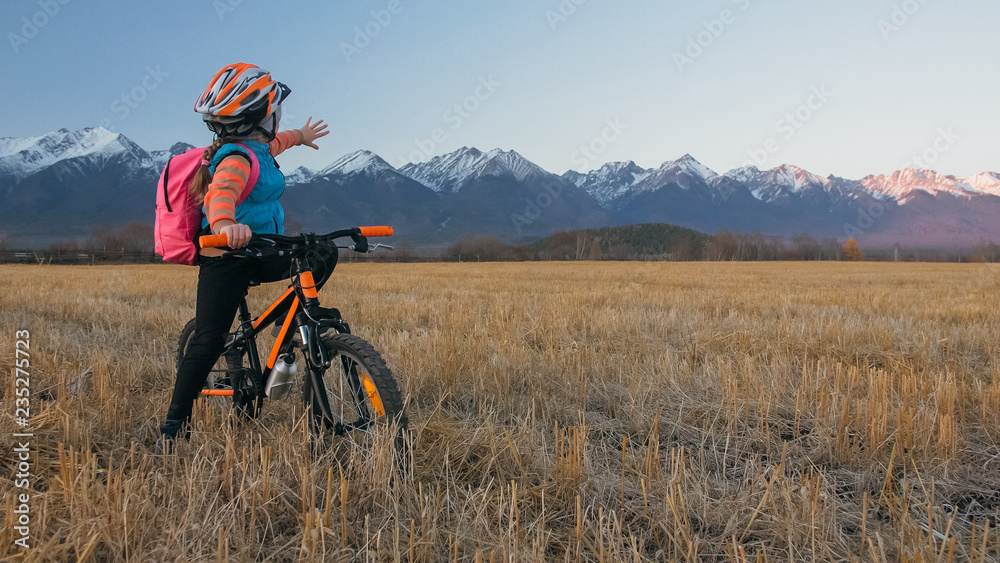 One caucasian children walk with bike in wheat field. Little girl ...