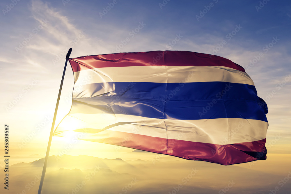 Thailand thai flag textile cloth fabric waving on the top sunrise mist ...