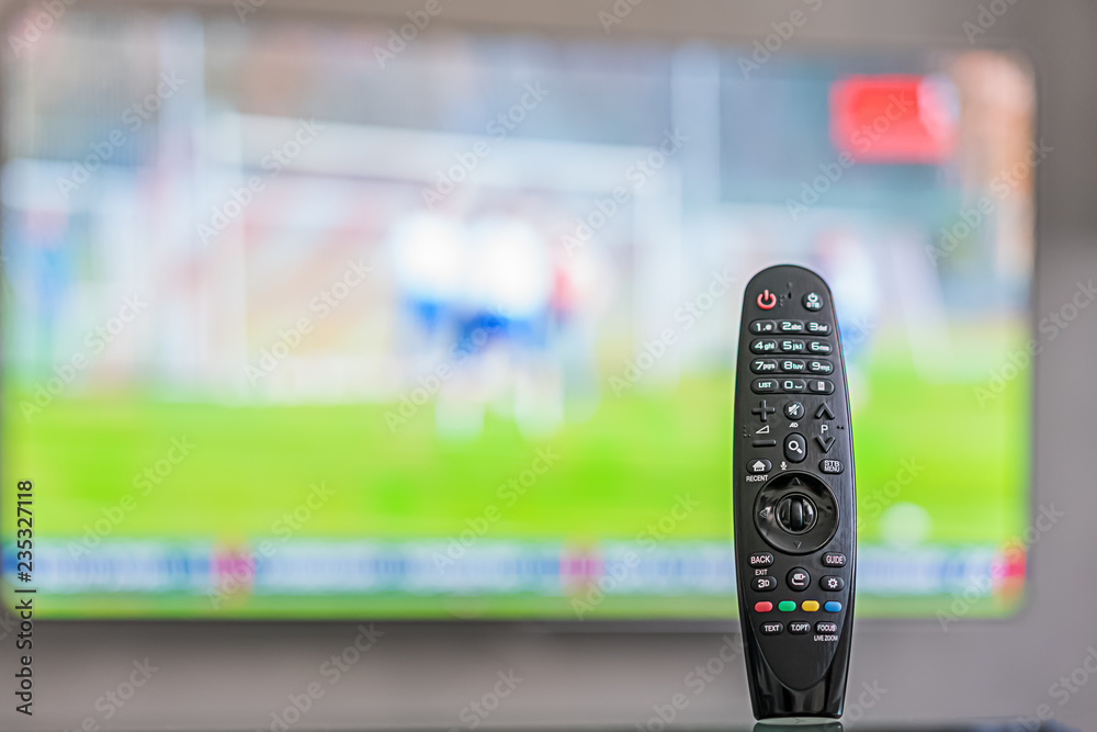 remote control broadcast TV stands on the table to the right, sports ...