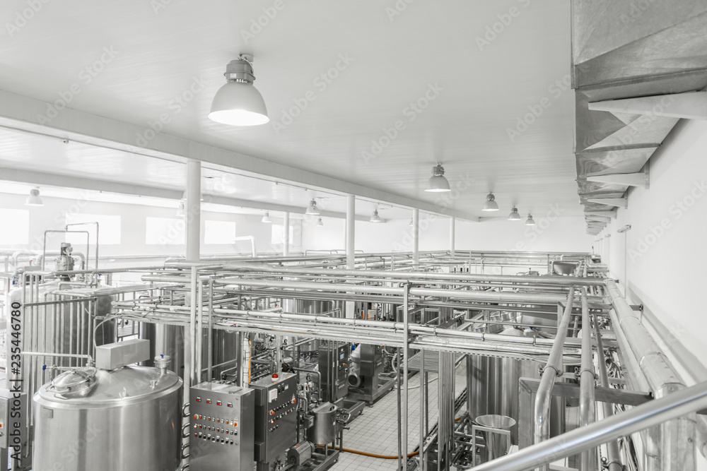 general view of the interior of a milk factory. equipment at the dairy ...