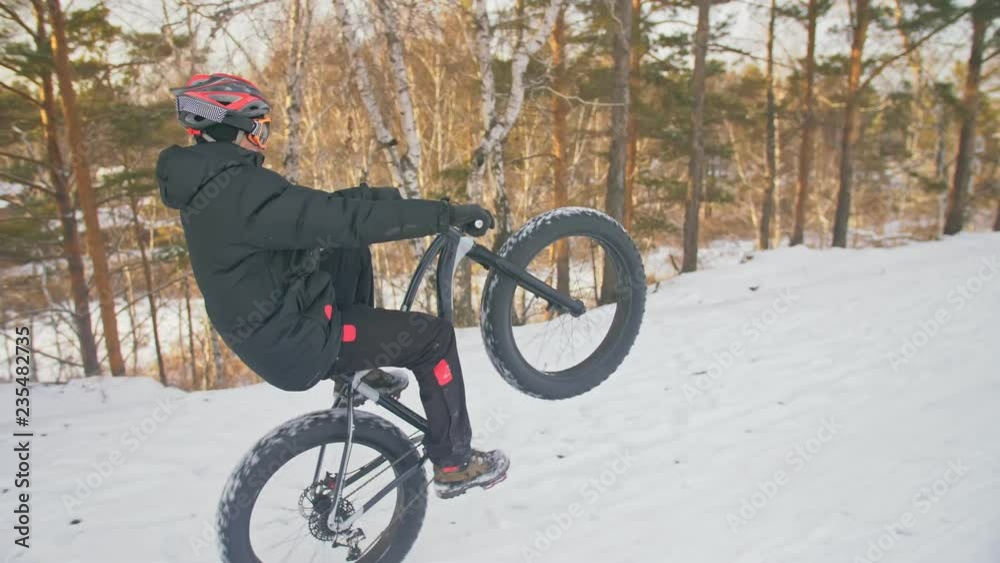 Professional extreme sportsman biker riding fat bike in outdoors ...