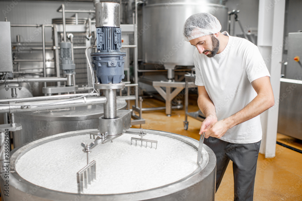 Poster Man mixing milk in the stainless tank during the fermentation ...