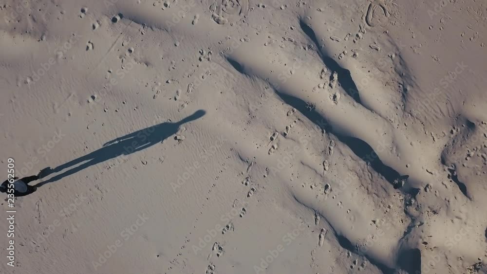 Aerial shooting. Three mens converge in the desert. The sun throws ...