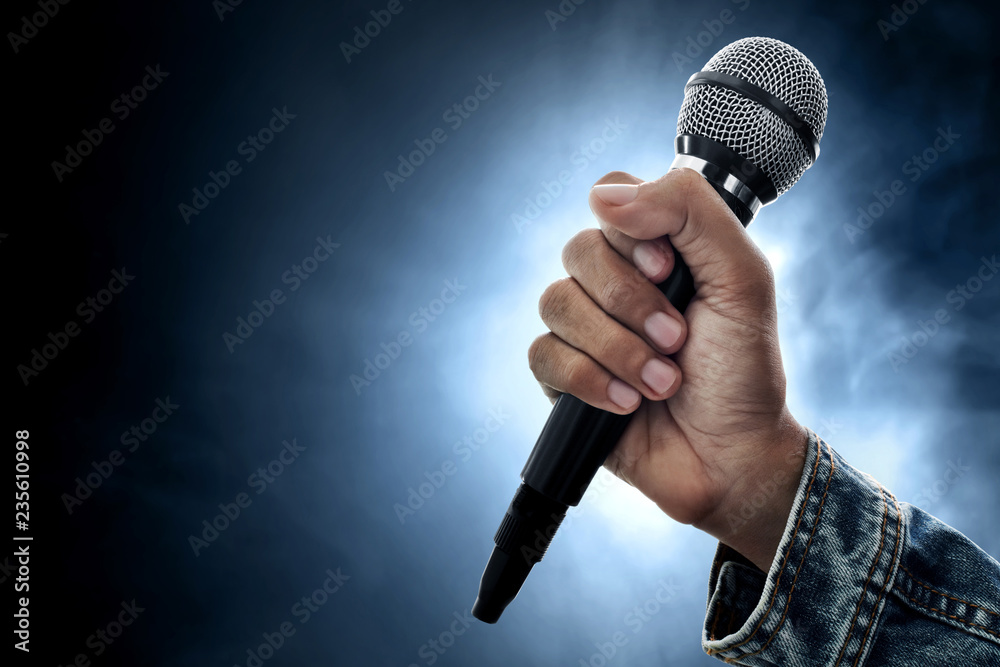 Hand holding microphone Stock Photo | Adobe Stock