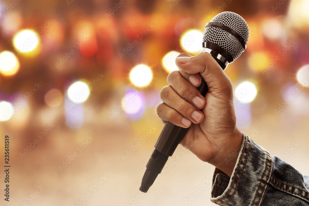 Hand holding microphone Stock Photo | Adobe Stock