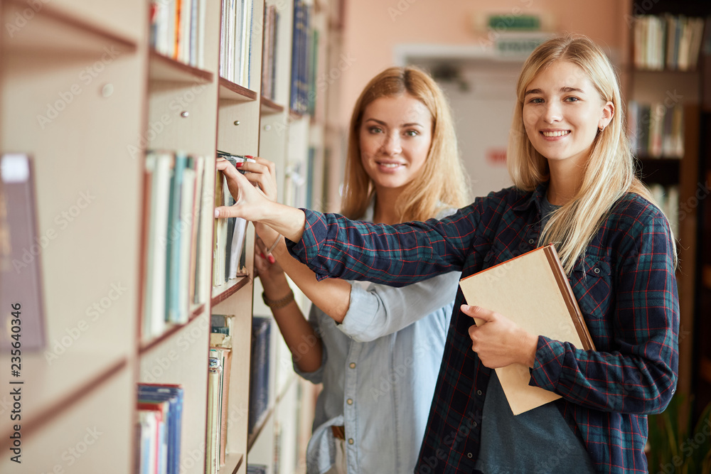Couple of young female designers come to public library for new ideas ...