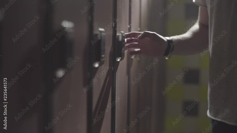 Man's hand opening locker with electric key on his wrist at gym in the ...