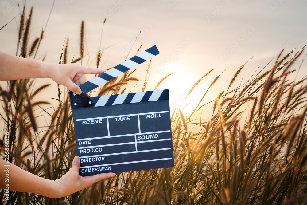 Man hands holding movie clapper isolated on nature background. Shown ...