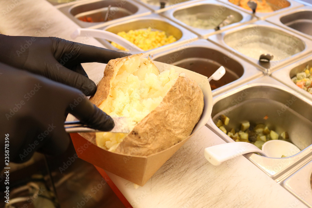Chef cook in black gloves is making Kumpir - Turkish traditional meal ...
