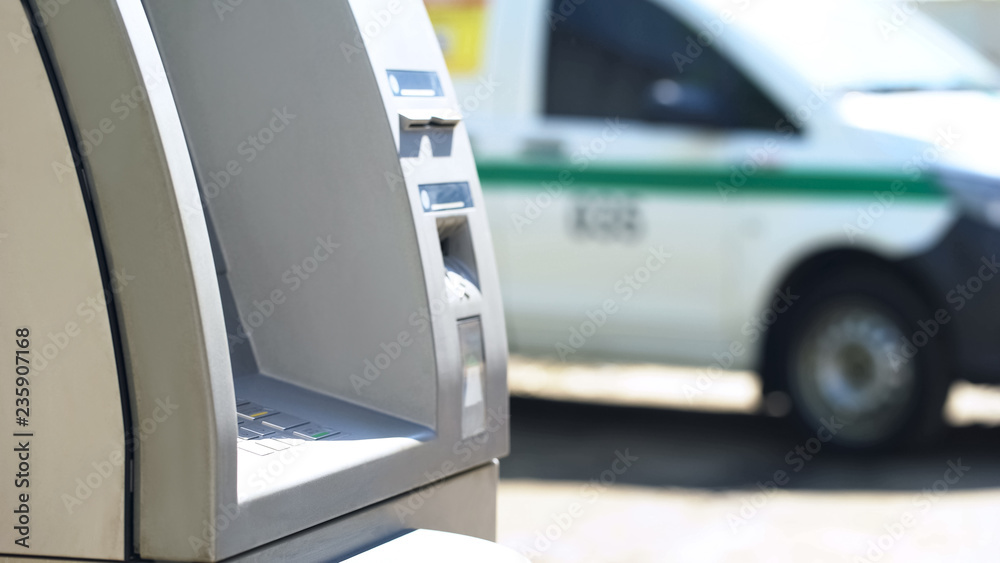 Automated teller machine standing against cash-in-transit vehicle ...
