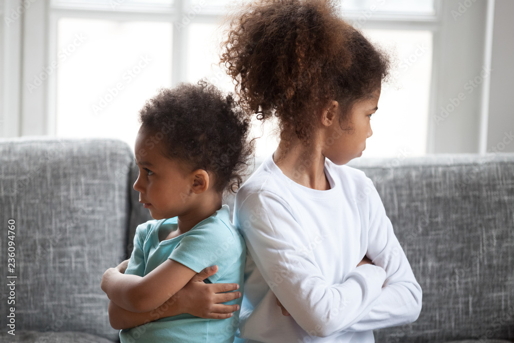 Foto de Offended African American siblings sitting ignoring, turning ...