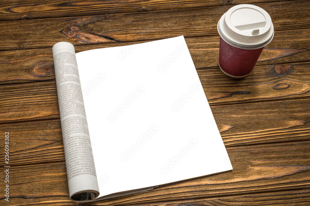 mock up a magazine and coffee on a brown wooden background. Clean sheet ...