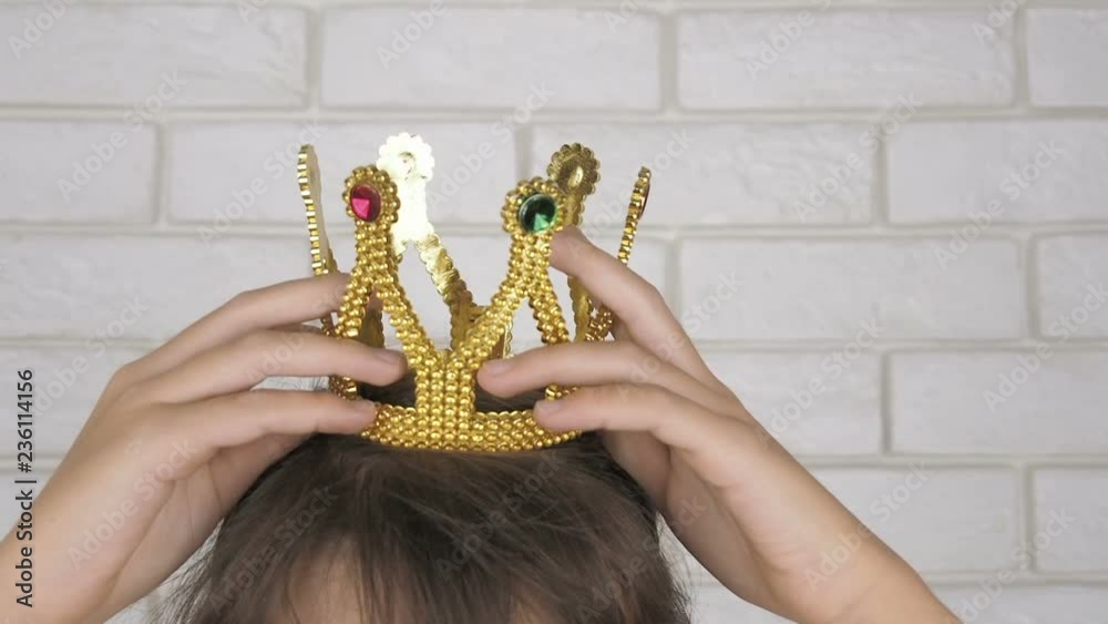 Putting on the crown. The girl puts the crown on her head. Stock ビデオ ...