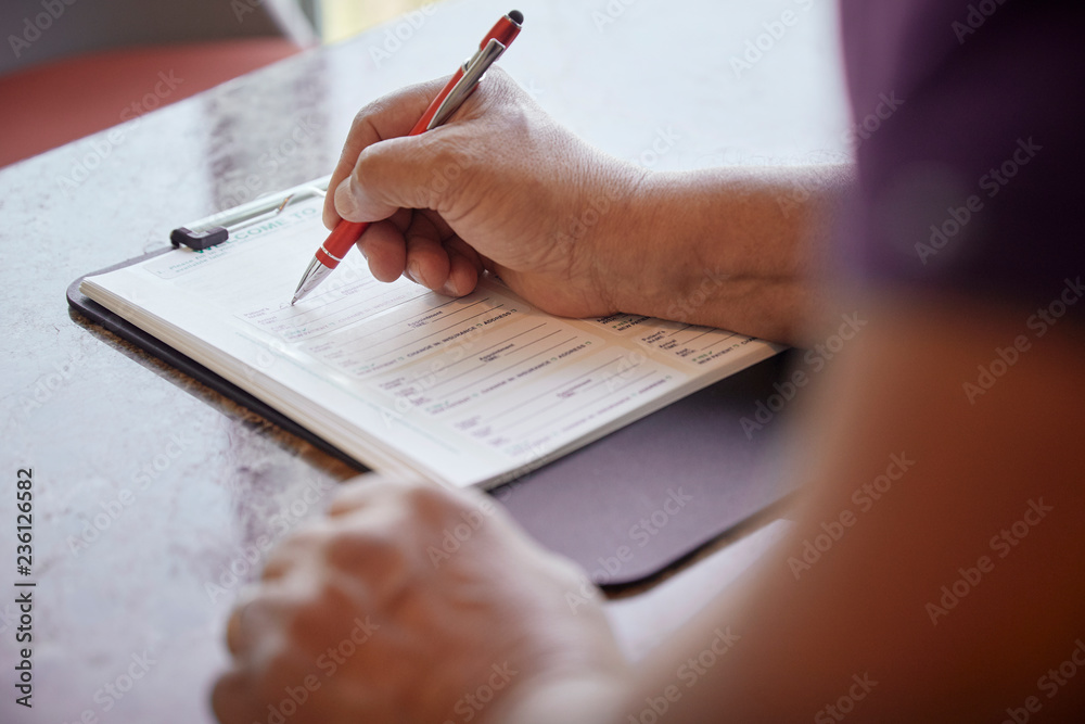 Person filling out a medical form Stock Photo | Adobe Stock
