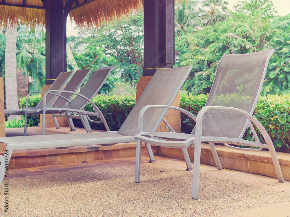 Sun beds with a metal frame and stretched mesh are under a canopy ...