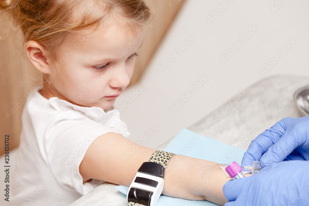 Nurse takes a blood sample from little girls arm - pediatric ...