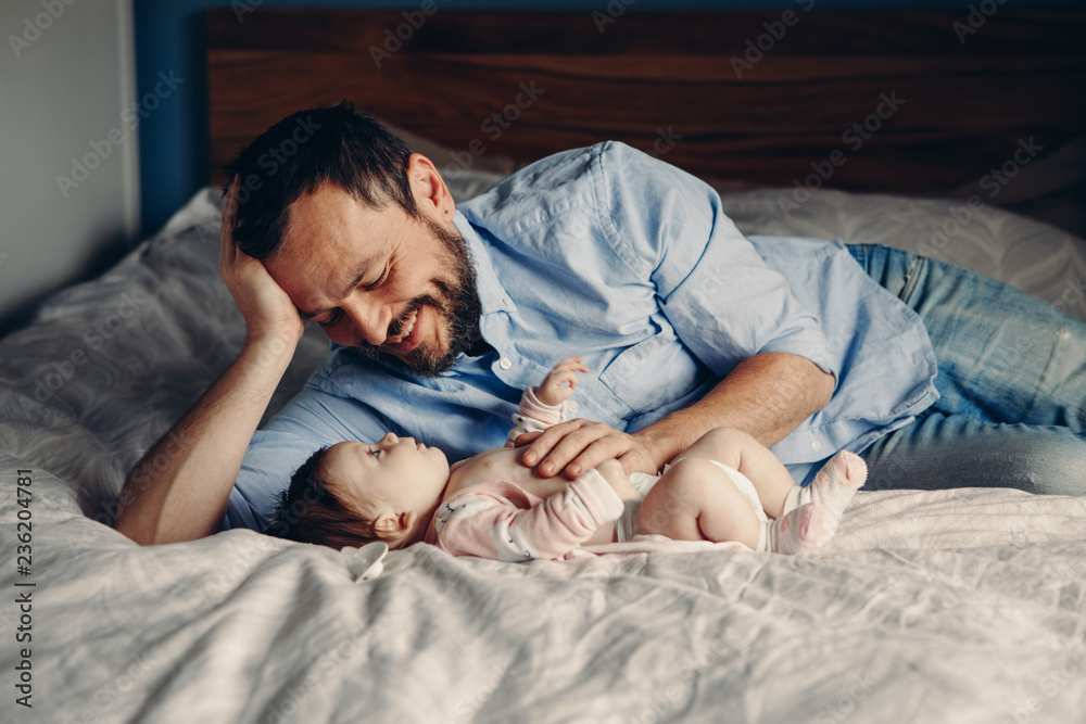 Portrait of middle age Caucasian father talking to newborn baby son ...