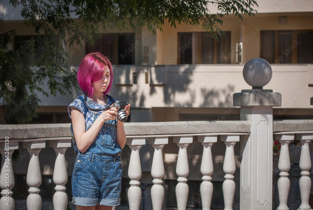 Girl in jeans clothes shooting with instant camera, snapshots outdoor ...