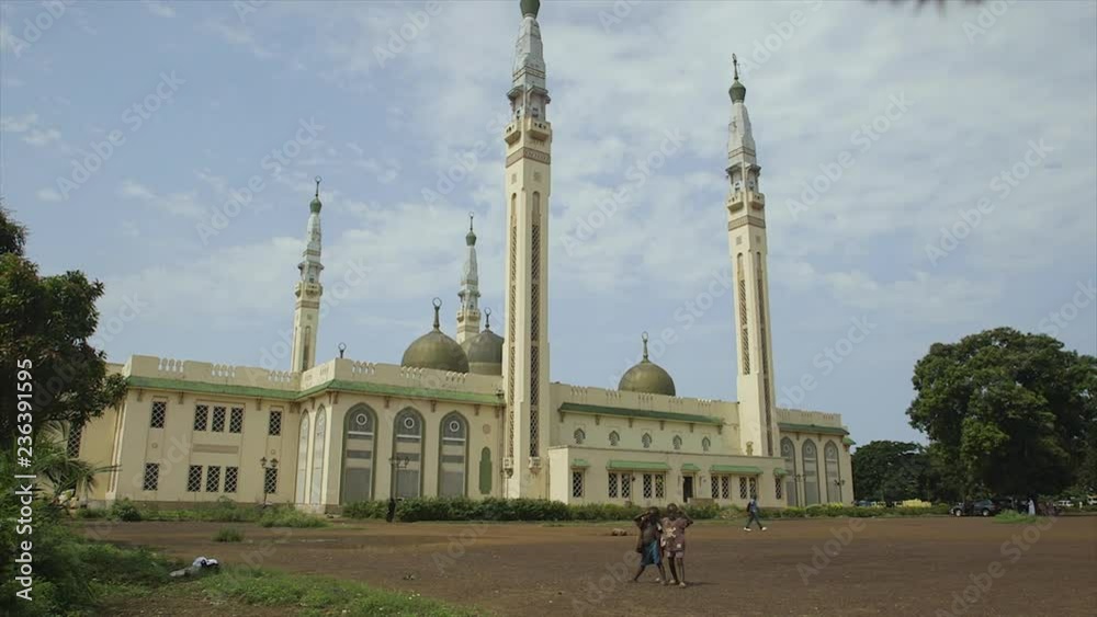 Wide, low-angle still shot, side view of grand Mosque of Conakry ...