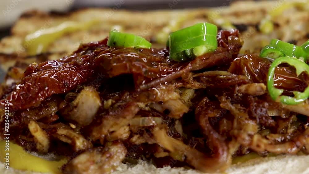 Close up of Green chillis on ripped chicken on a mini ciabatta loaf ...