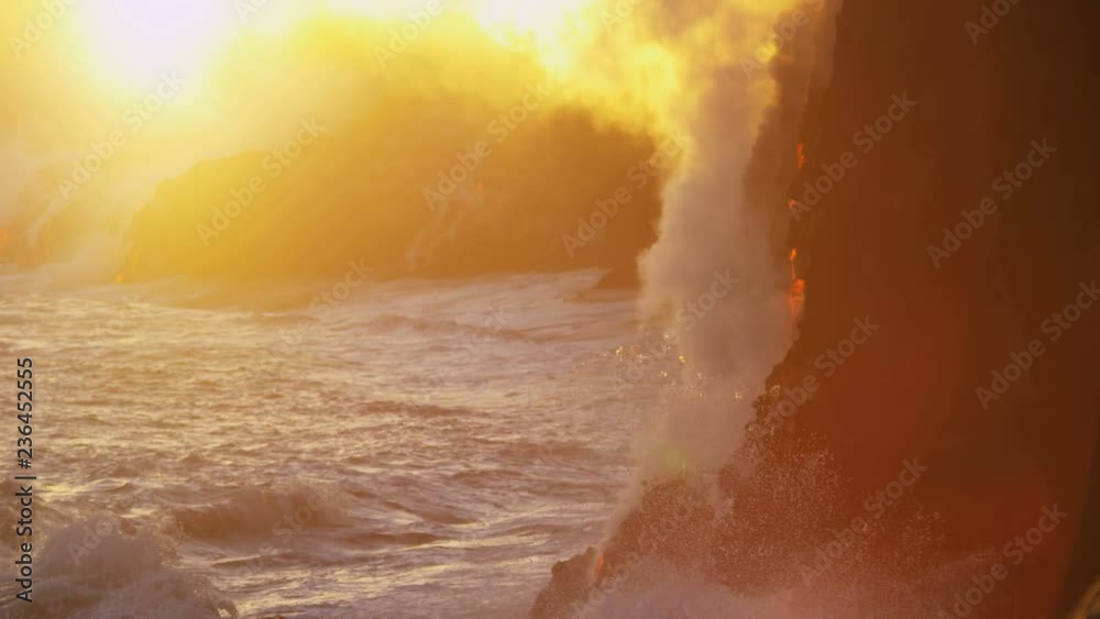 Red hot lava falling into ocean at sunrise causing rising steam seen ...