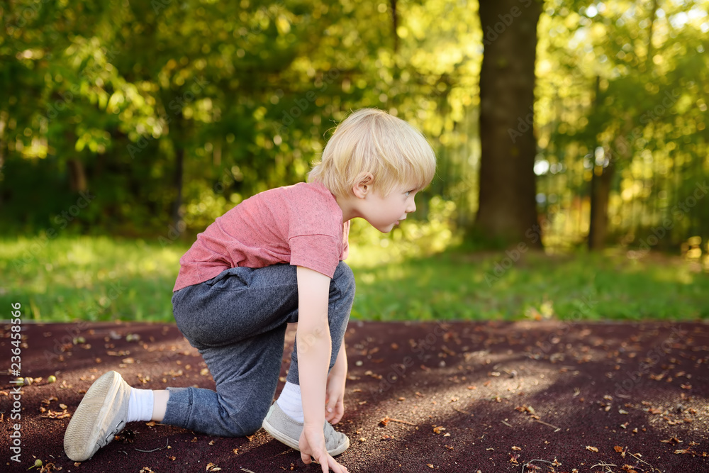 Little boy sportsman getting ready to run a distance at the school ...