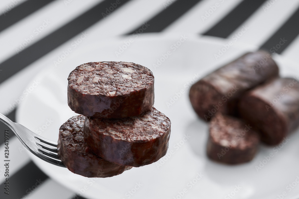 Black pudding on black and white striped background. Morcilla de Burgos ...