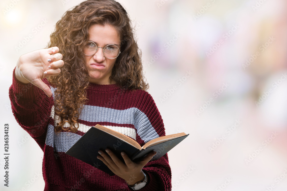 Young brunette girl reading a book wearing glasses over isolated ...