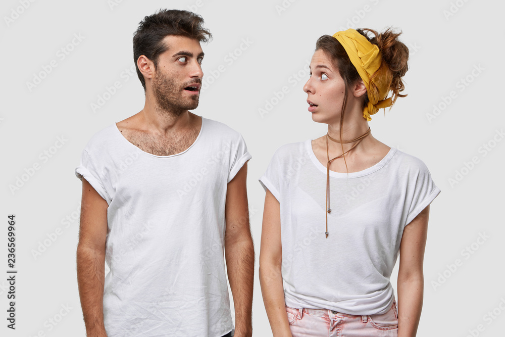 Suprised female and male discuss something unbelievable, look with ...