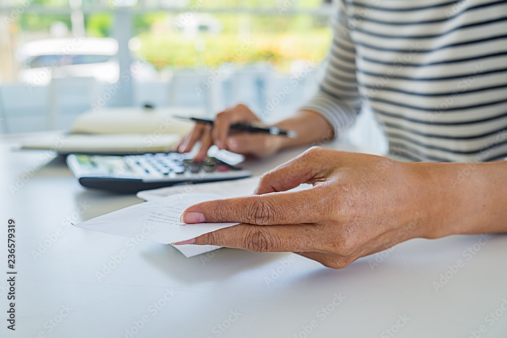 Woman with bills and calculator. Woman using calculator to calculate ...