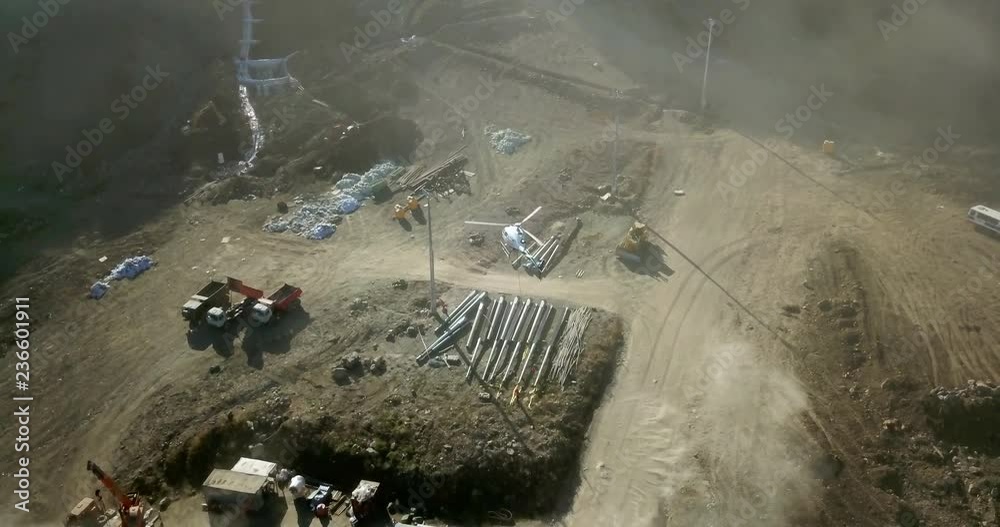 Helicopter transporting building materials over construction site view ...