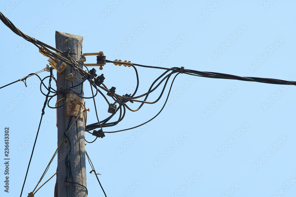 Greek wooden electricity pole with many wire connections against a blue ...