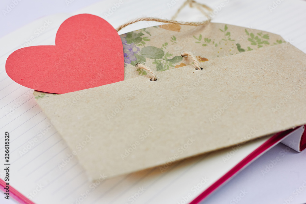 Red paper valentine in a shape of heart in vintage cardboard envelope ...